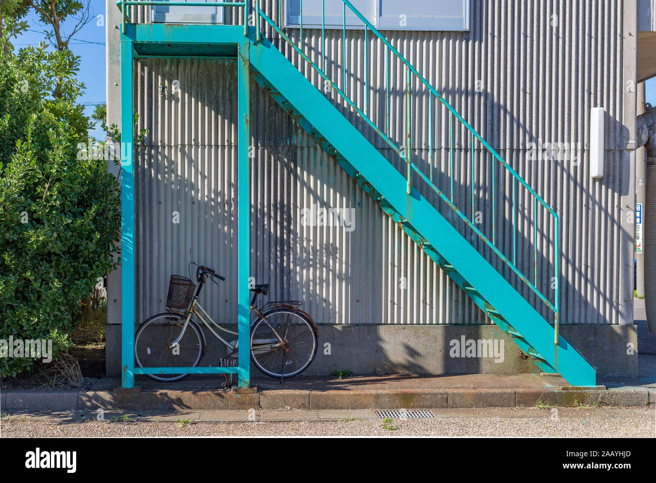 Brightly painted metal staircase with bicycle underneath, dockside ...
