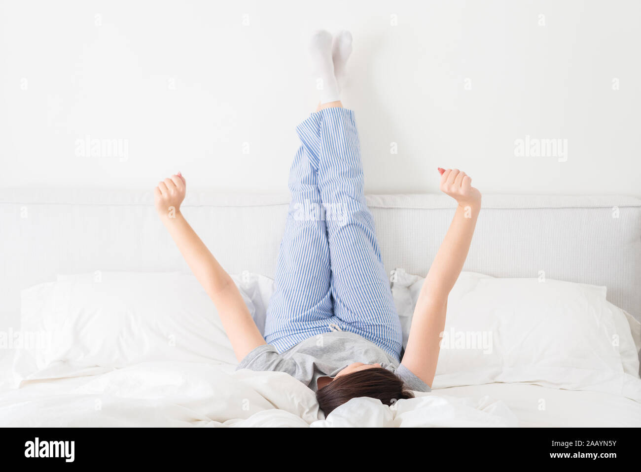 beautiful woman legs raised up high lying on bed in bedroom Stock Photo ...