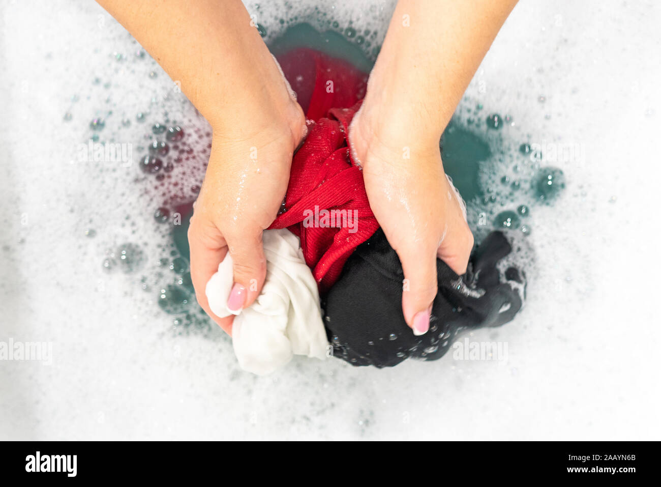 Female hands washing color clothes in basin Stock Photo - Alamy