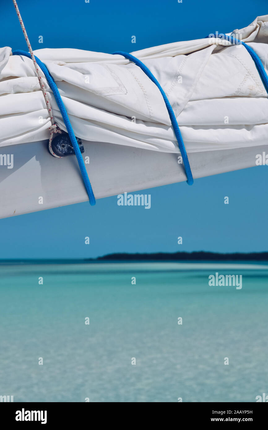 Sailboat mast with rolled sail and the Caribbean Sea at the background ...