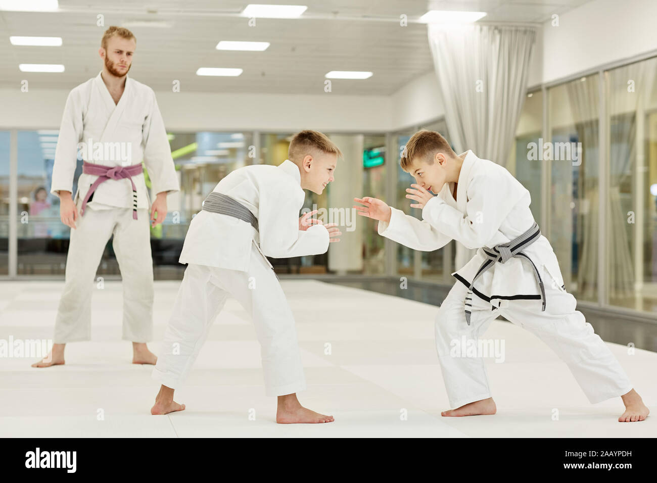 Two boys in kimono learning to fight during training in karate while ...