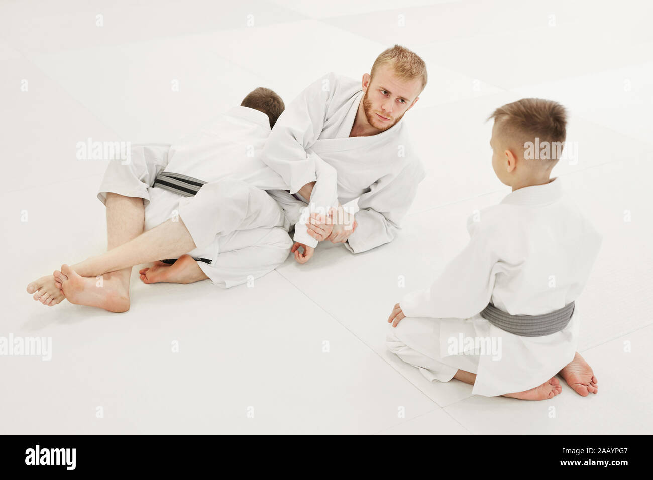Young coach showing the technique to his students during training ...