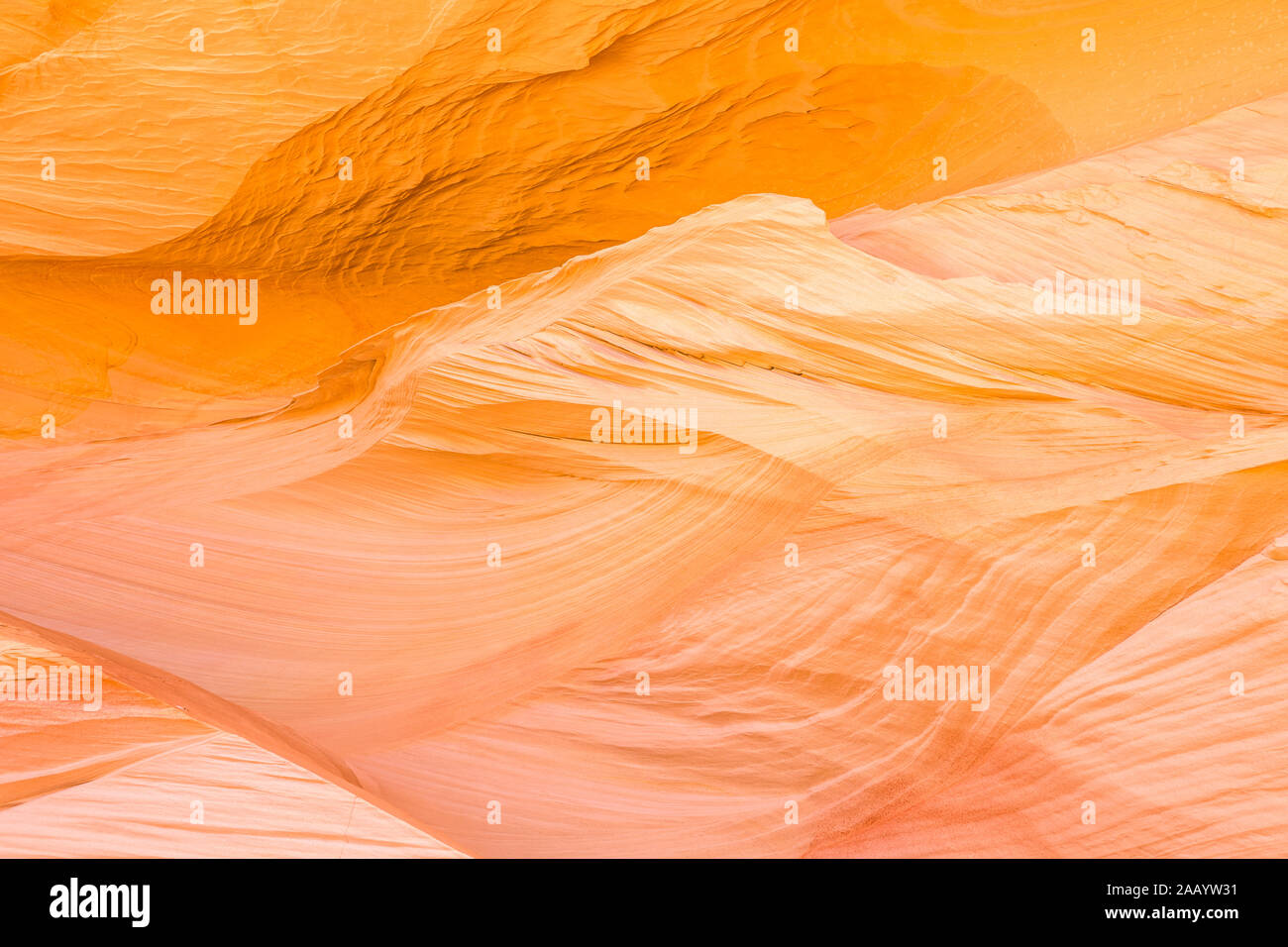 Wind blasted soft sandstone weathered into waves and lines in orange ...