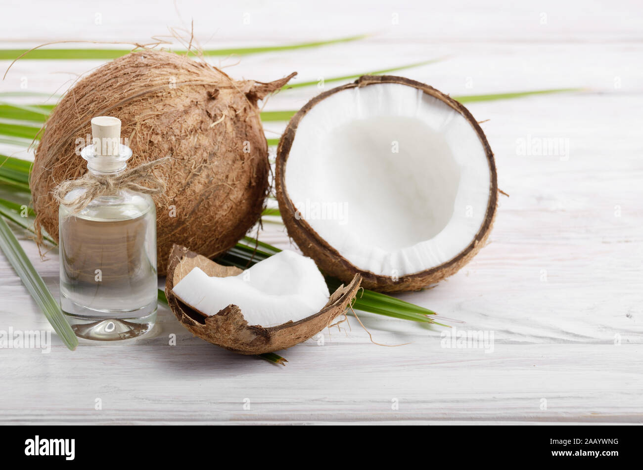 Coconut oil in glass jar and shell pieces on white wooden table Stock ...