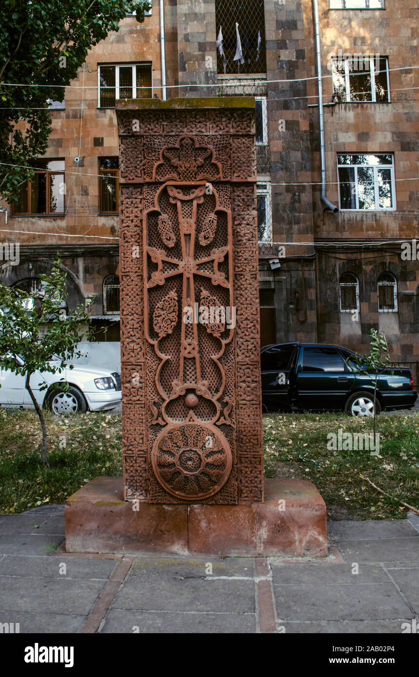 Openwork khachkar made of red tuff with a figured arch over the cross ...