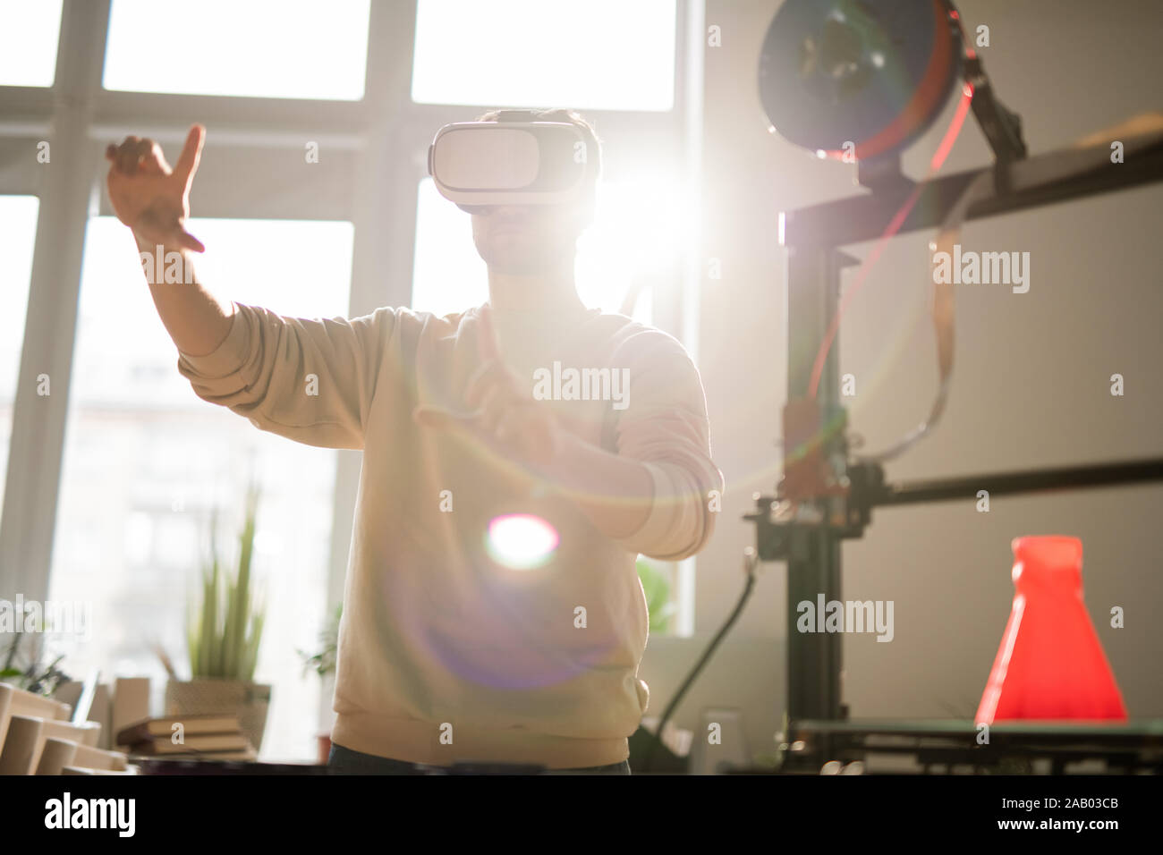 Contemporary guy or office worker in vr headset pointing at virtual ...