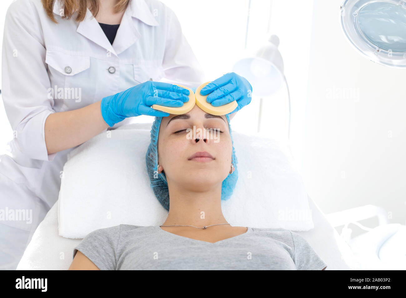 A woman, a professional doctor, a beautician cleanses the patient's ...