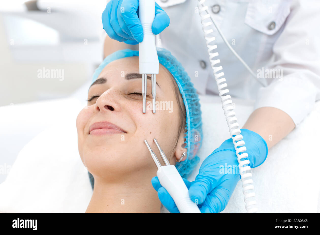 Portrait of a young beautiful girl face microcurrent therapy procedure ...