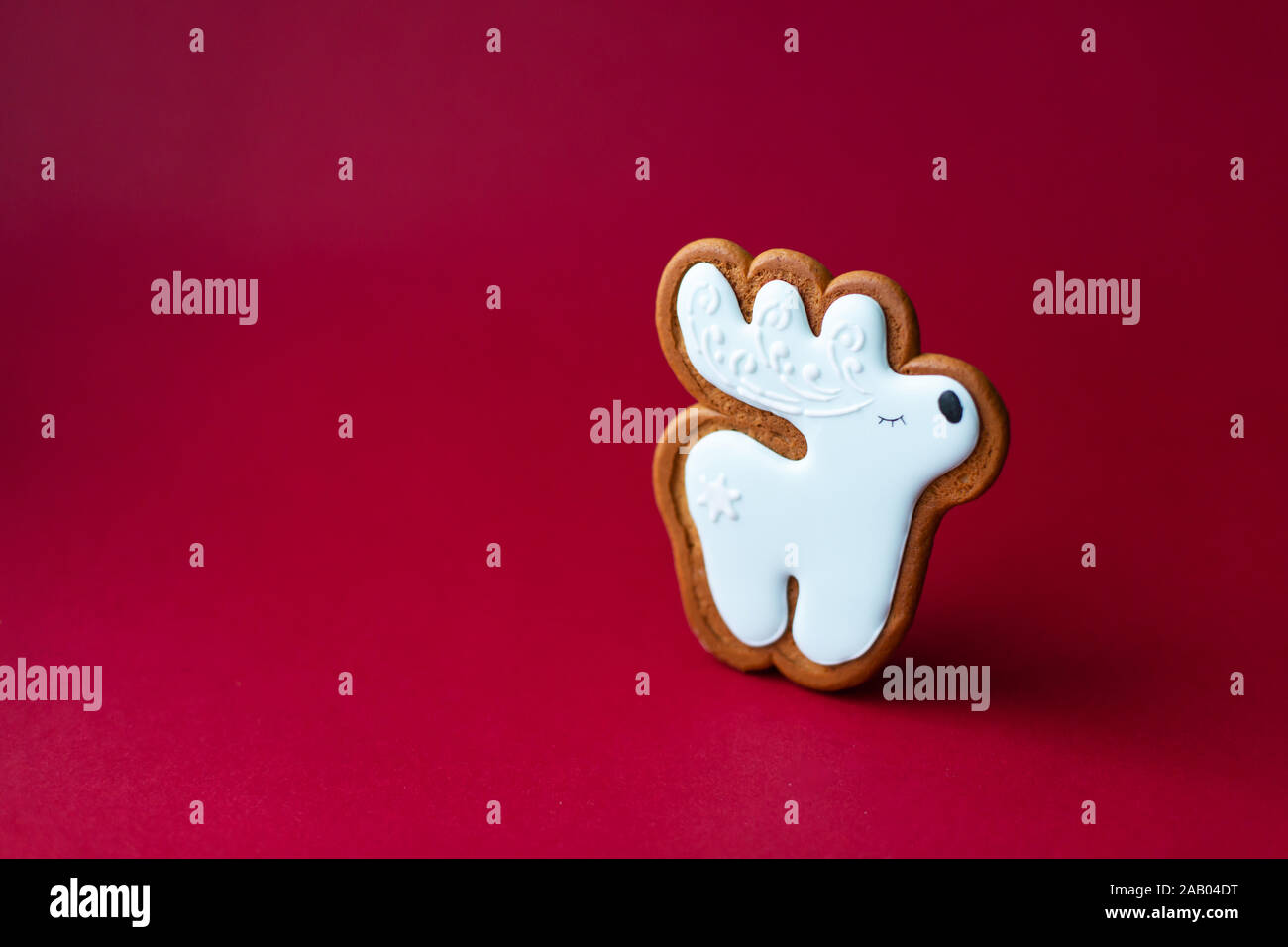 gingerbread cookie of little cute deer on red background. Traditional ...