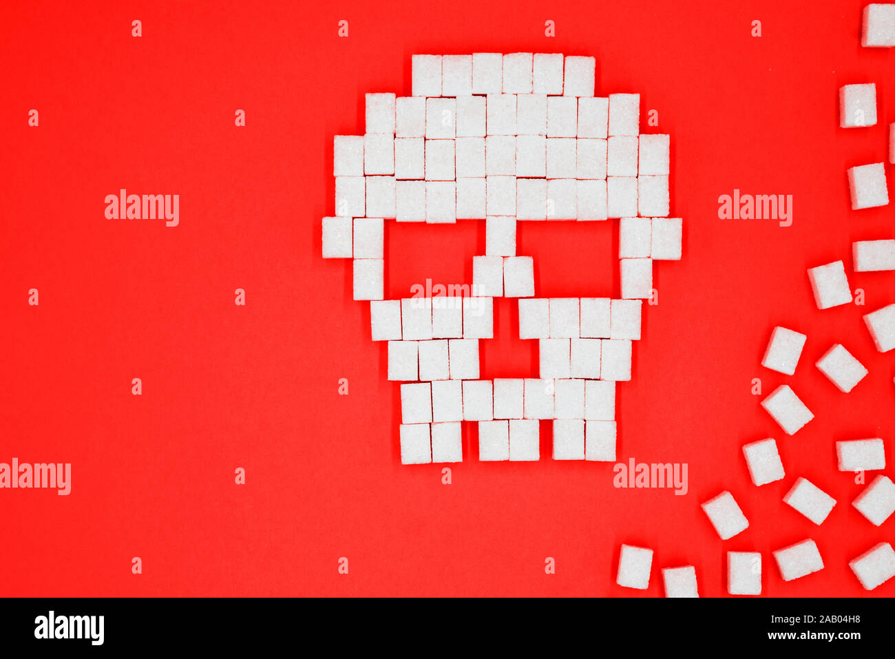 Sugar cubes laid out in shape of skull. Concept that sugar and sweets ...