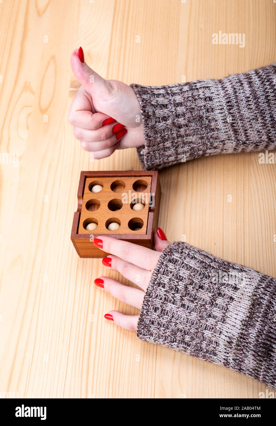 The girl raised her thumb up after assembling the puzzle. Wooden puzzle ...