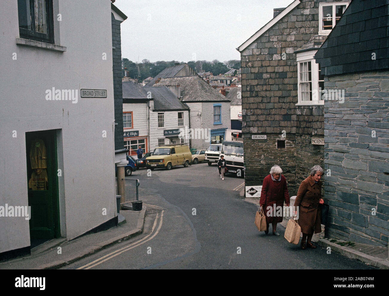Two ladies walking up narrow hill in Padstow, North Cornwal, England ...