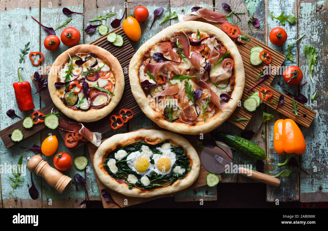 Homemade pizza party. Flatlay of puffy rustic pizzas with pancetta ...