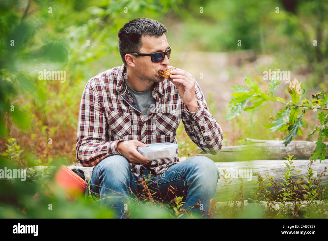 Hungry man eating. Sandwich outdoors. hiker eating sandwich sitting in ...