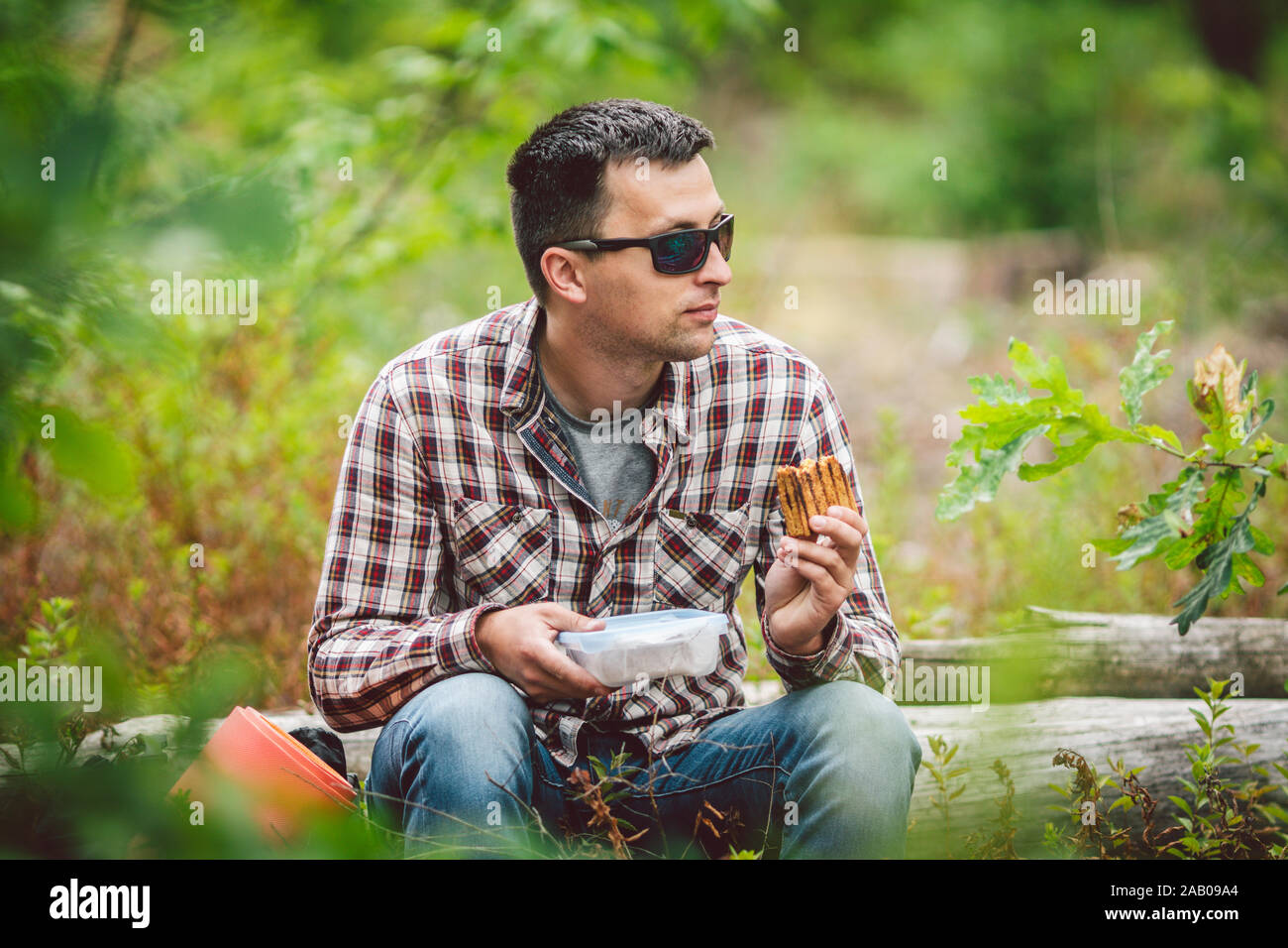 Hungry man eating. Sandwich outdoors. hiker eating sandwich sitting in ...