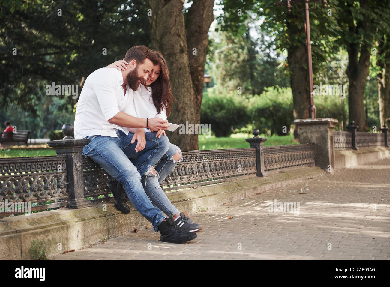 Young couple looking at a smartphone on a sunny day in the city Stock ...