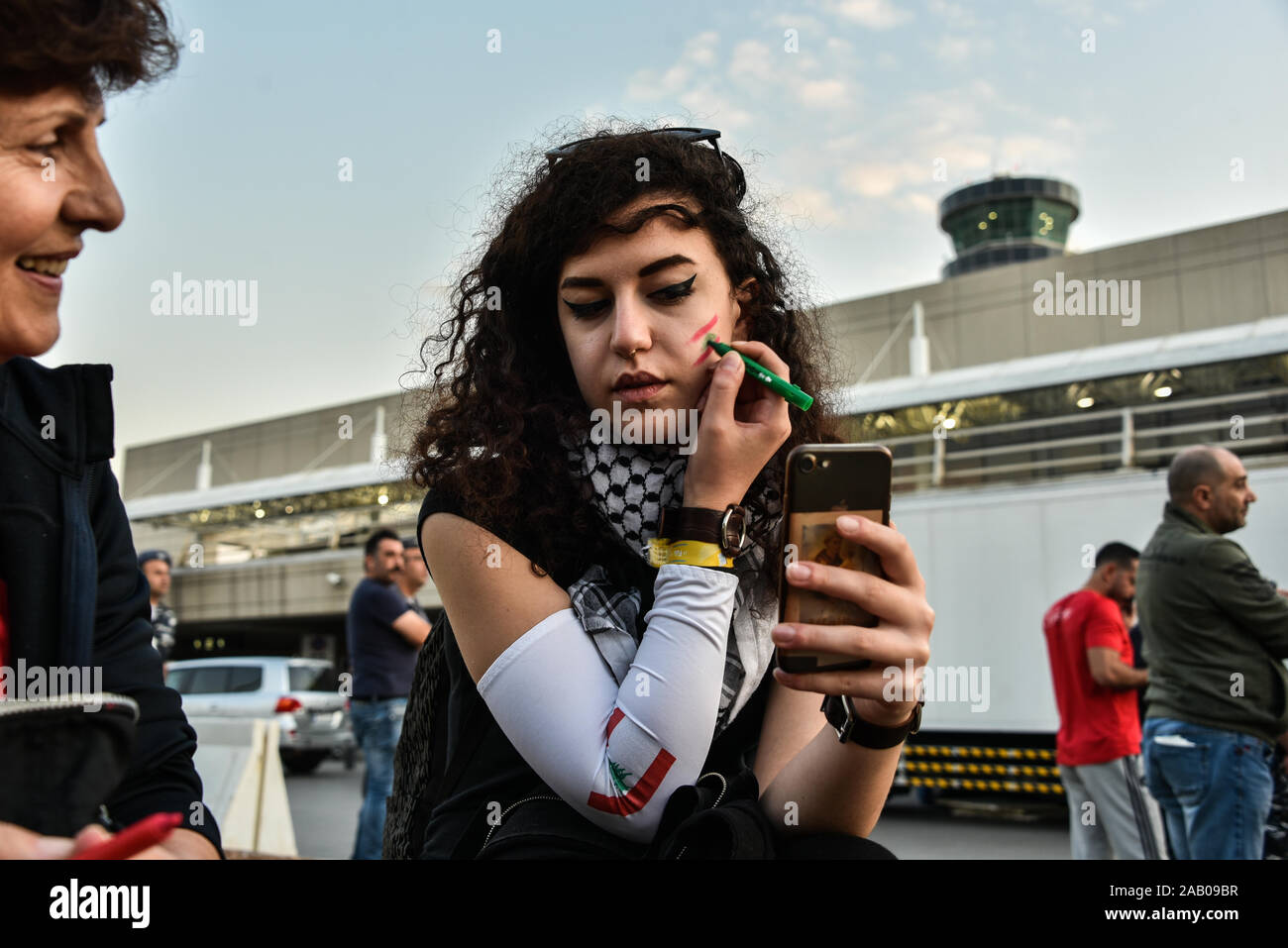 A woman draws the Lebanese flag on her cheek at Rafik Hariri Airport ...