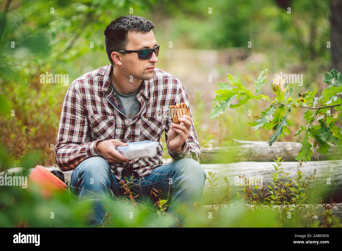 Hungry man eating. Sandwich outdoors. hiker eating sandwich sitting in ...