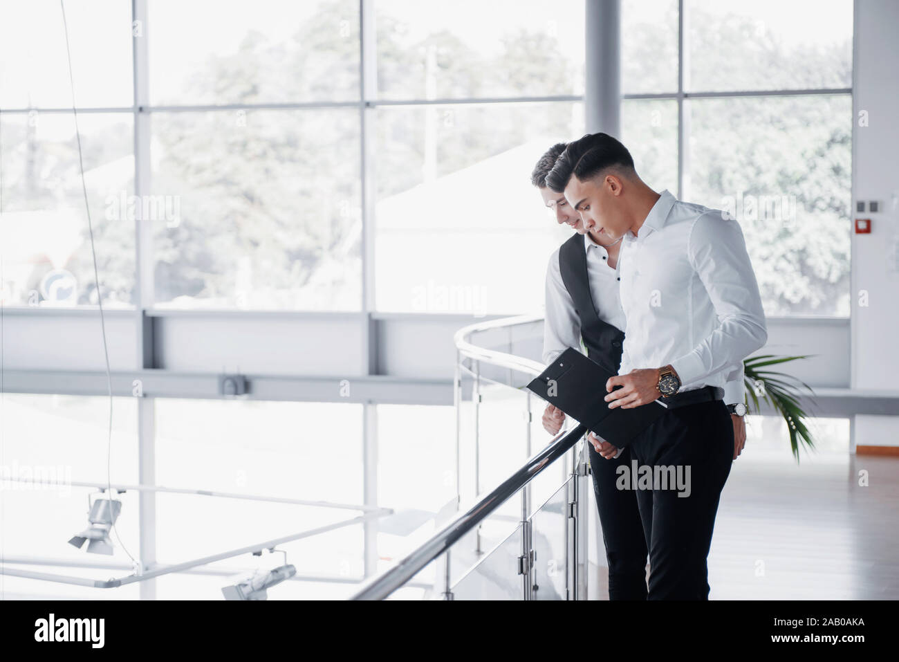 Young business people looking at documents and products standing at the ...