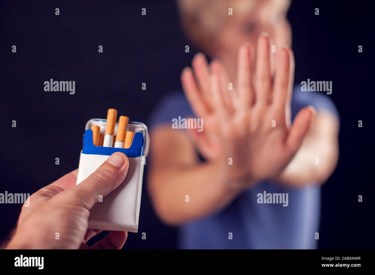 Woman in blue t-shirt refusing cigarettes on black background. Stop ...