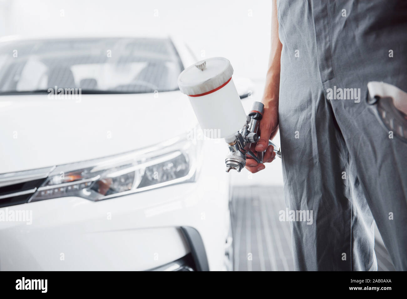 gun with paint in the hands of a man to paint a car Stock Photo - Alamy