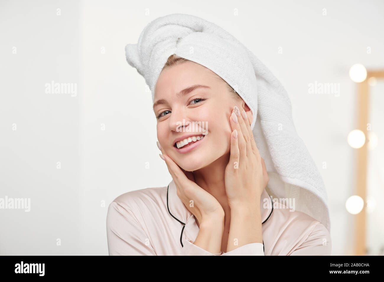 Healthy girl with toothy smile touching her clean hydrated face Stock ...