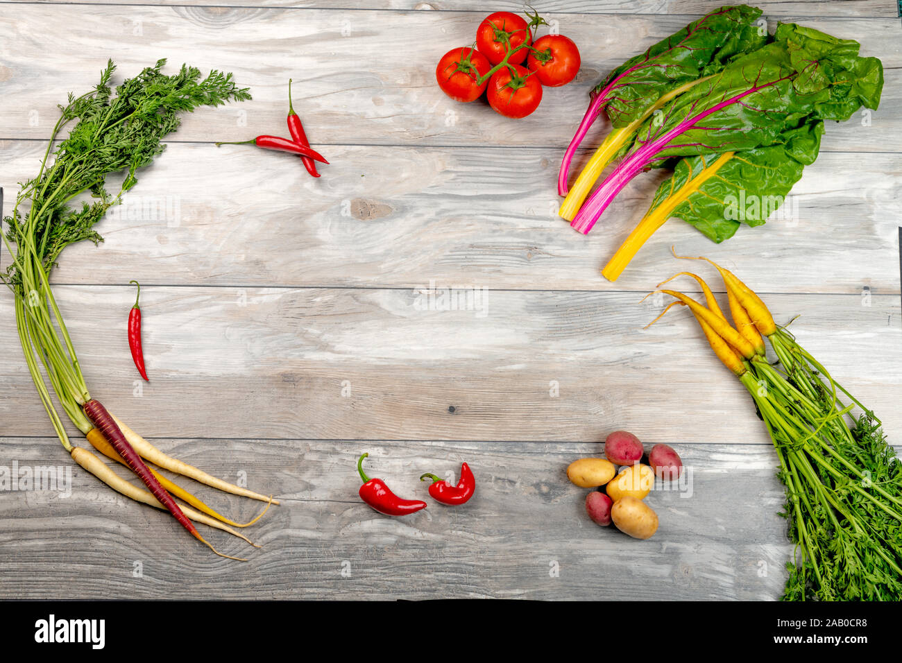Organic vegetables frame a wooden table center Stock Photo - Alamy