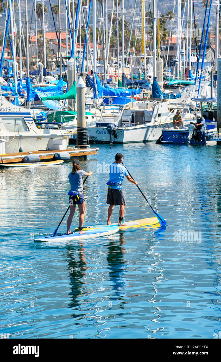 A young woman and man paddling on a stand up paddle board in the Santa ...