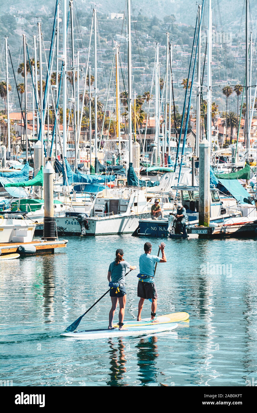 A young woman and man paddling on a stand up paddle board in the Santa ...