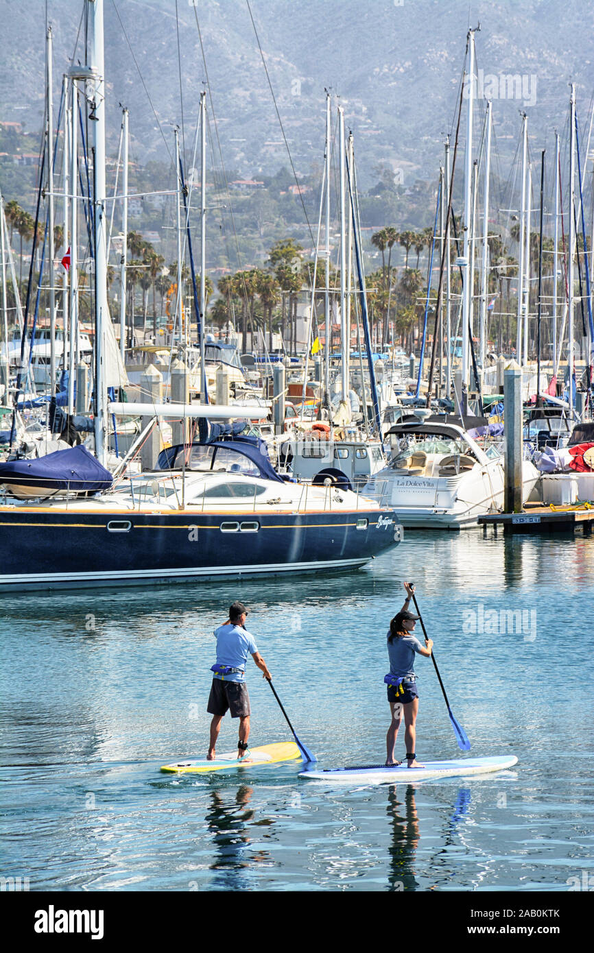 A young woman and man paddling on a stand up paddle board in the Santa ...