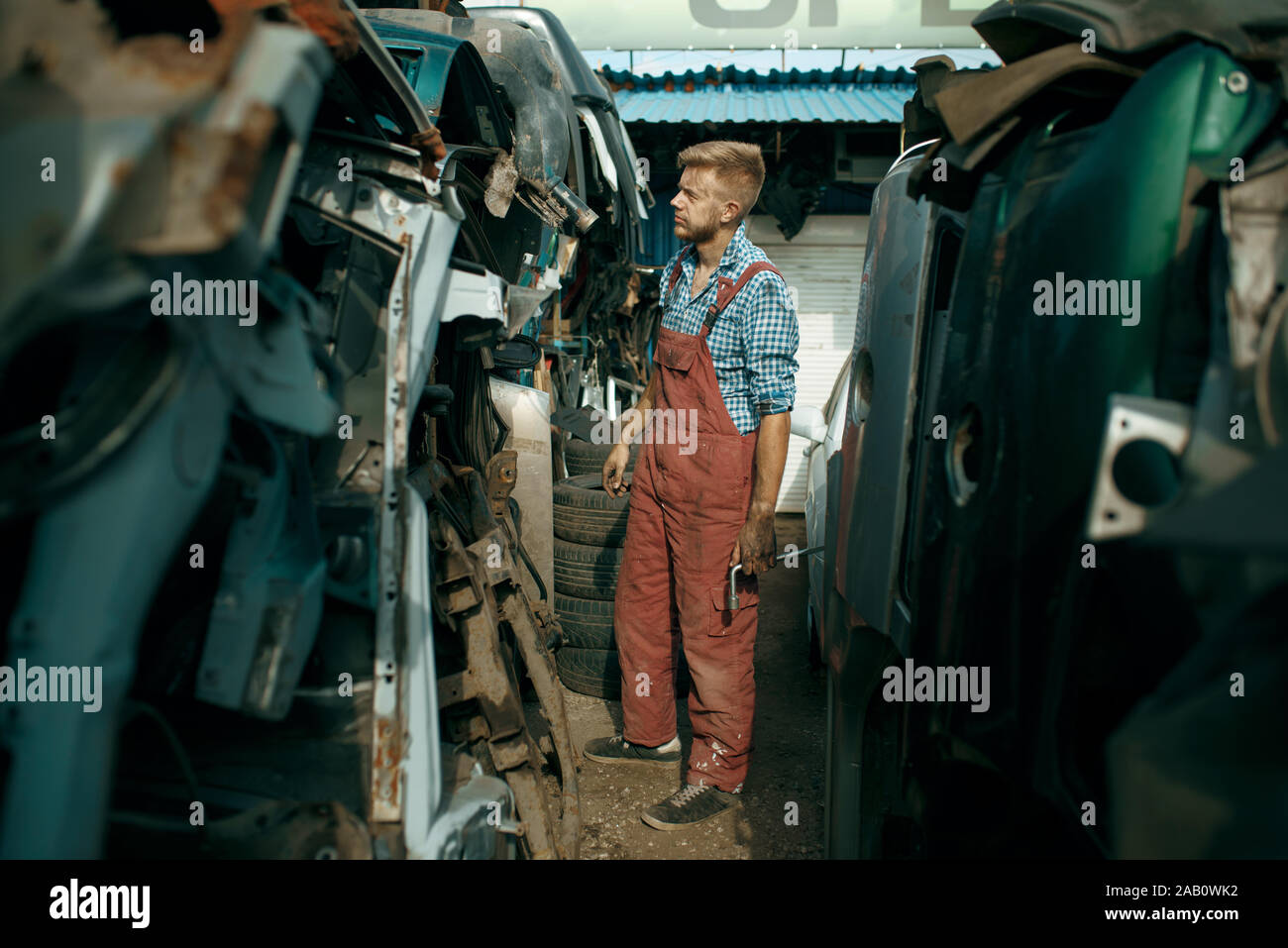 Male repairman choosing spare parts on car junkyard Stock Photo - Alamy