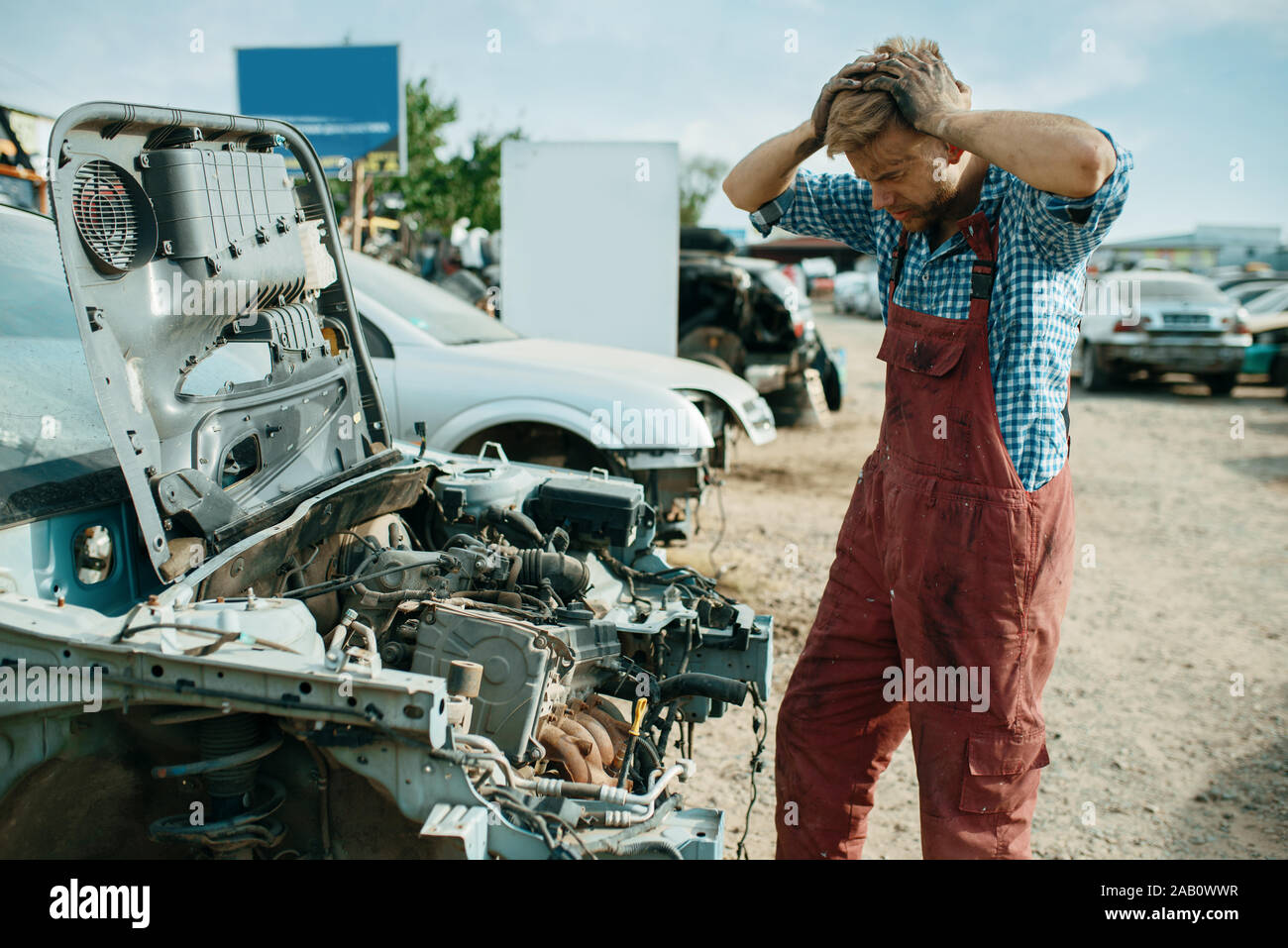 Angry male repairman works on car junkyard Stock Photo - Alamy