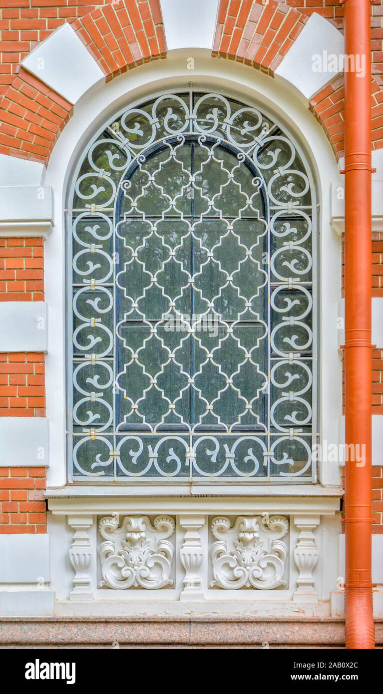 Close-up of ancient vintage arch window with cast iron white painted ...