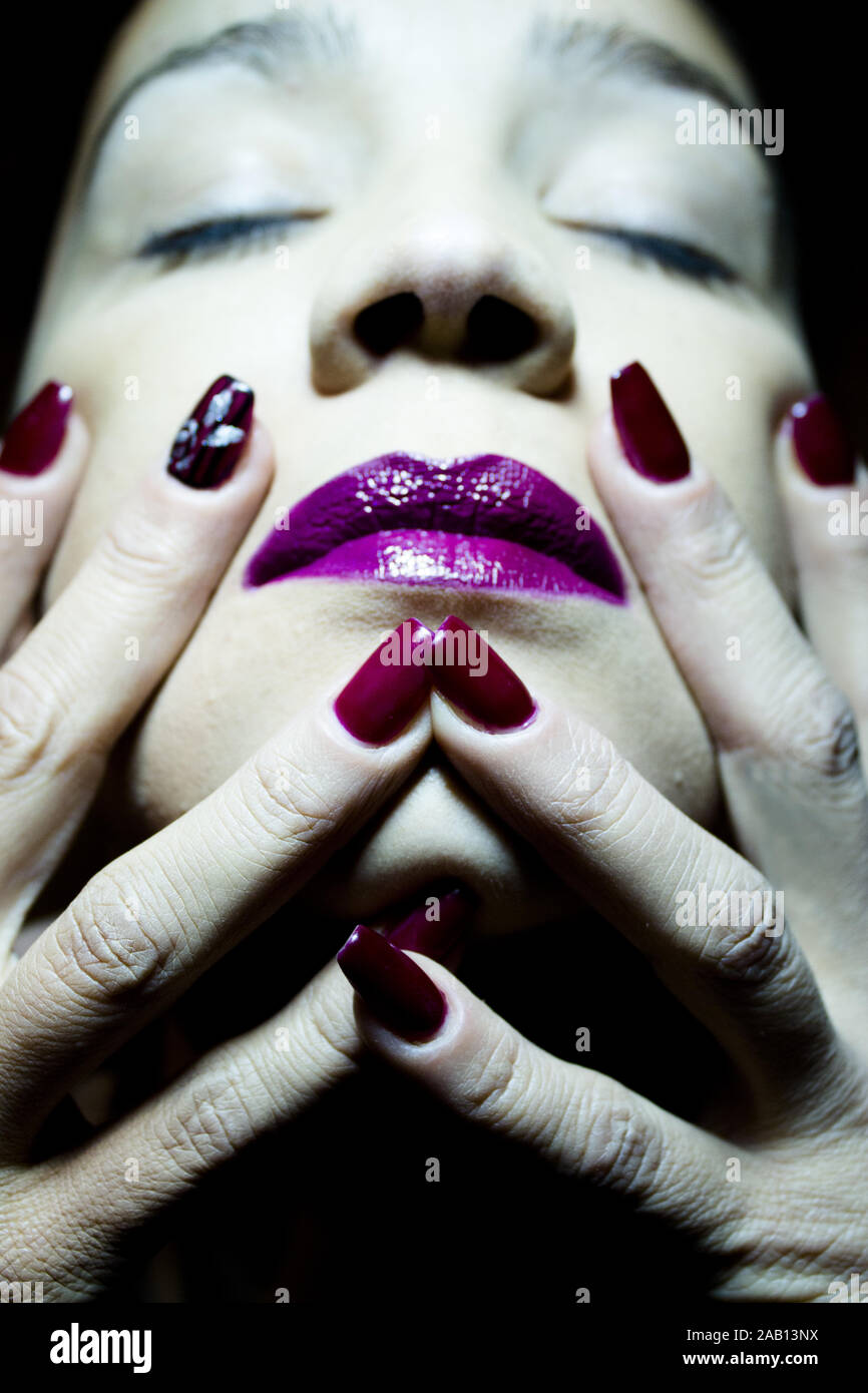 Portrait of woman with hand over face. Red makeup lips and nails Stock ...