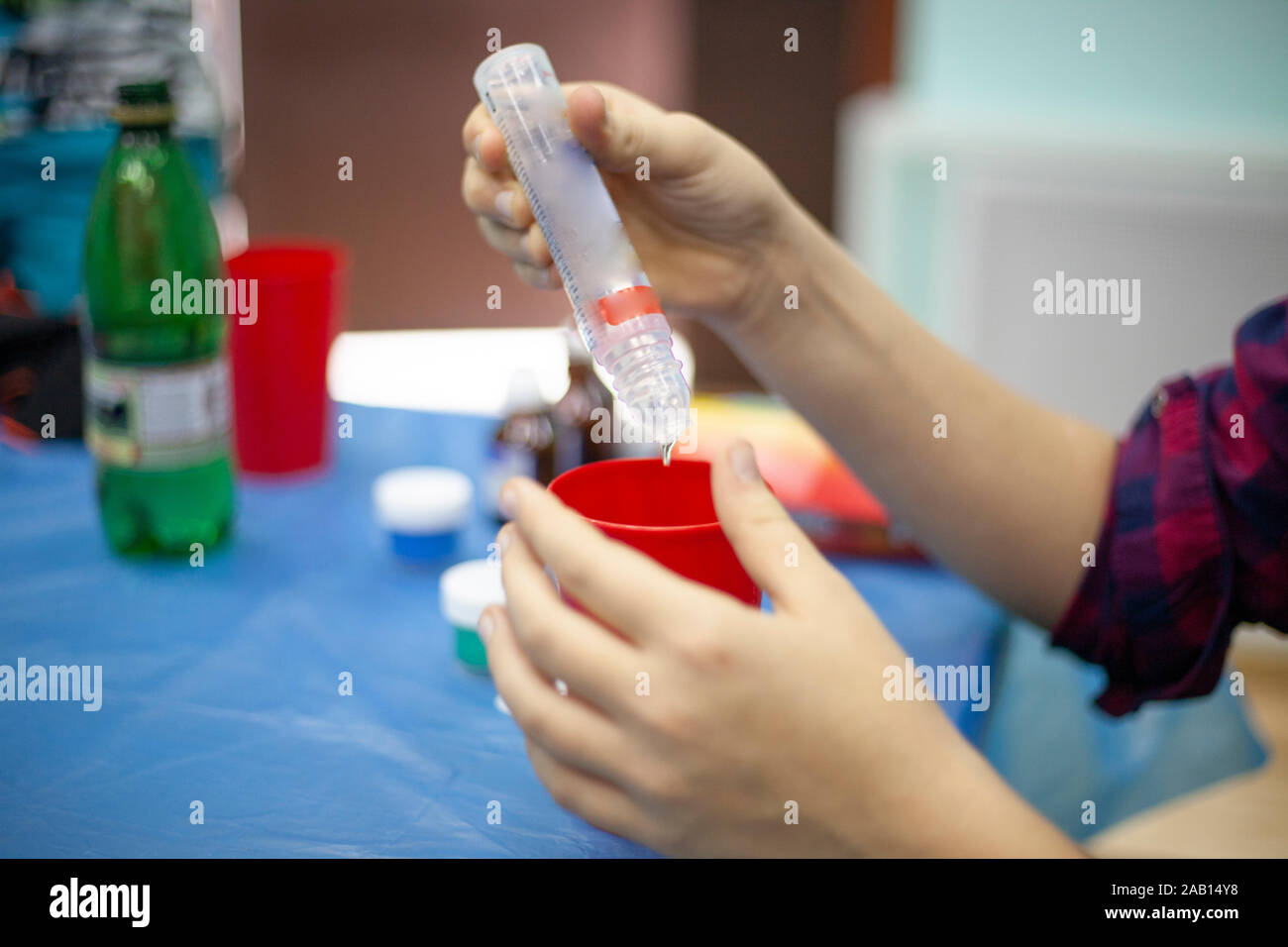 Creative activity. A tube of glue in the hands of a girl. Bonding the ...