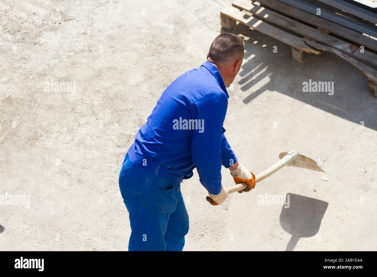 Photo of the Worker works with a shovel, cleaning rubble Stock Photo ...
