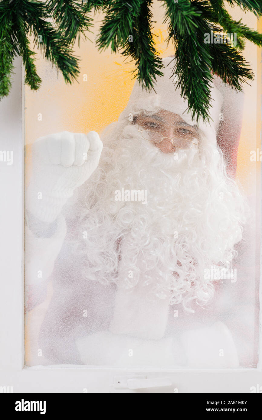 Santa Claus is knocking at the frozen window. View from home Stock ...