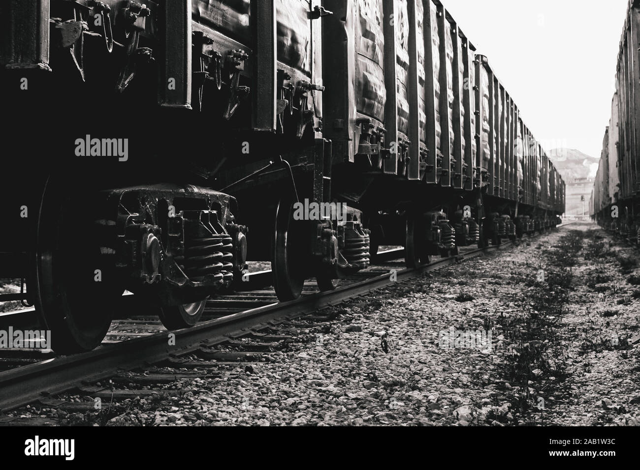 Freight wagons closeup on rails. Stylized black and white photo. A long ...
