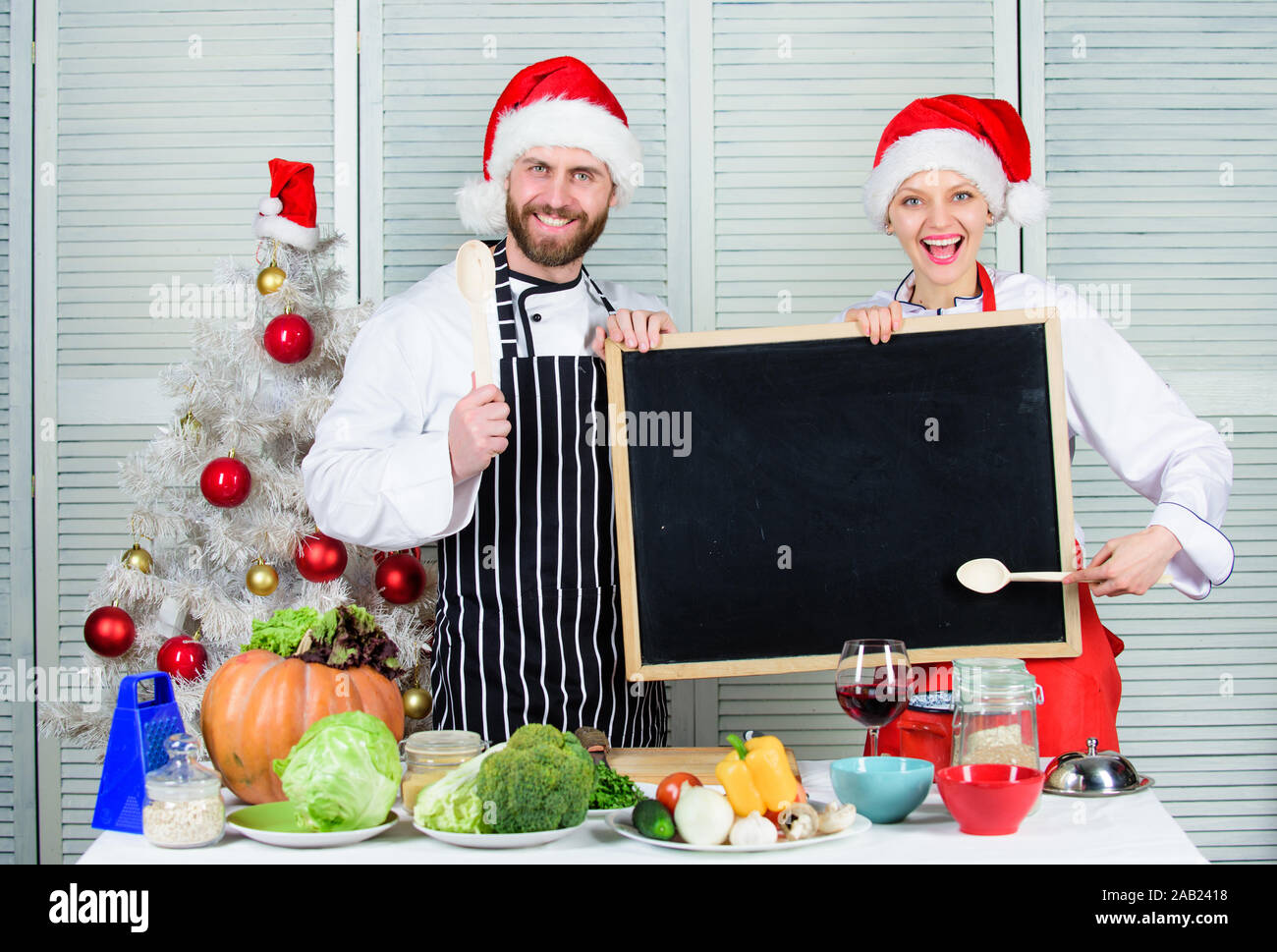 Man and woman chef santa hat near christmas tree hold blackboard copy ...