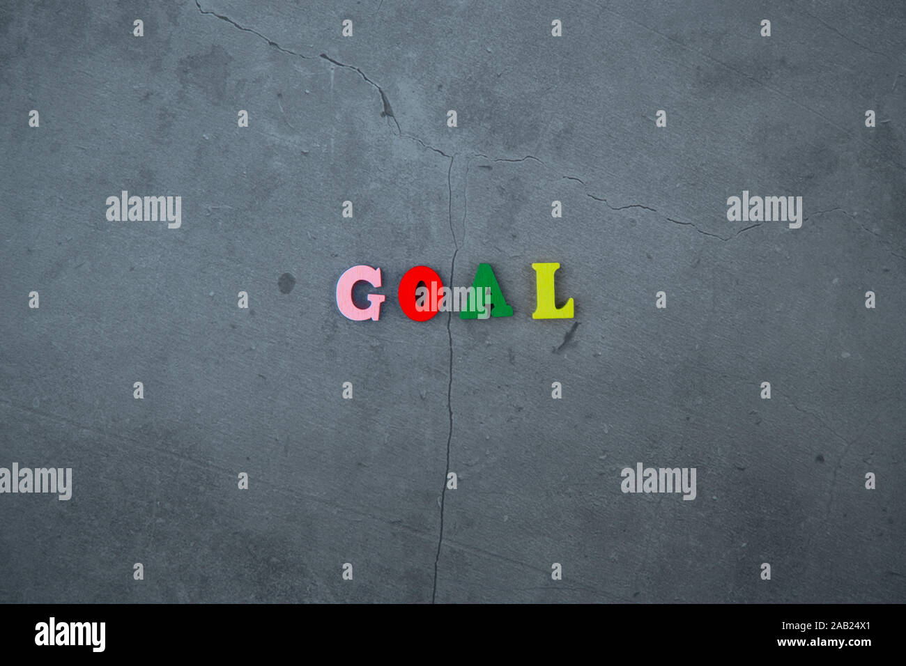 The multicolored goal word is made of wooden letters on a grey ...