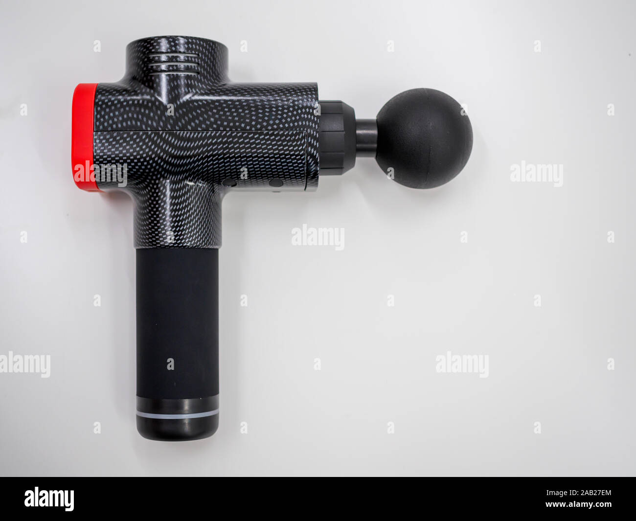 A therapeutic percussive massage gun isolated against a white ...
