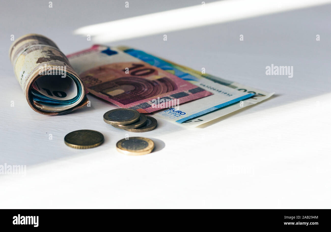 Rolled up money euro banknotes and coins on white background Stock ...