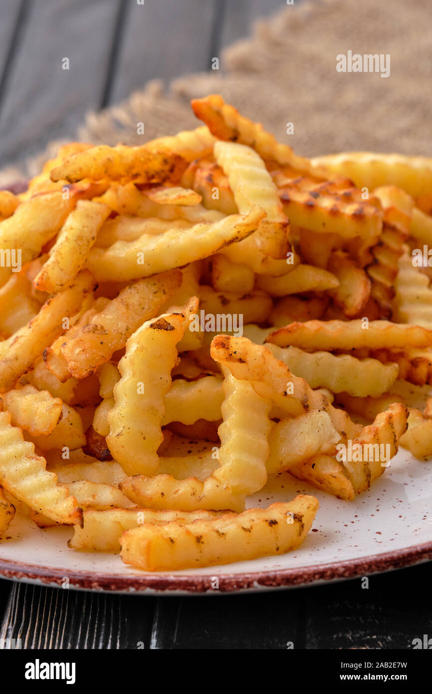 Fried crinkle cut french fries Stock Photo - Alamy