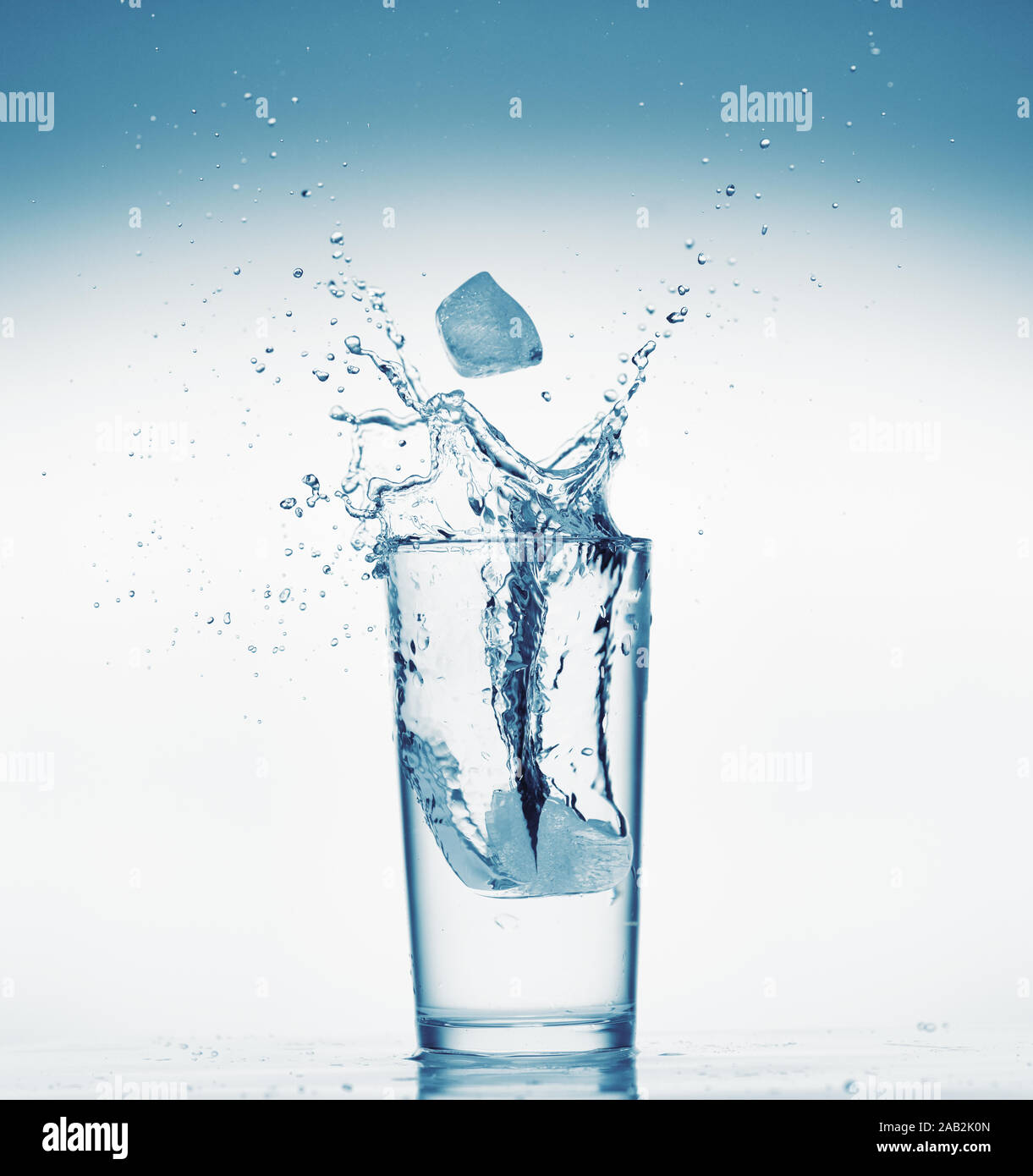 one glass of water with splash from falling ice cube, white background, isolated object Stock ...