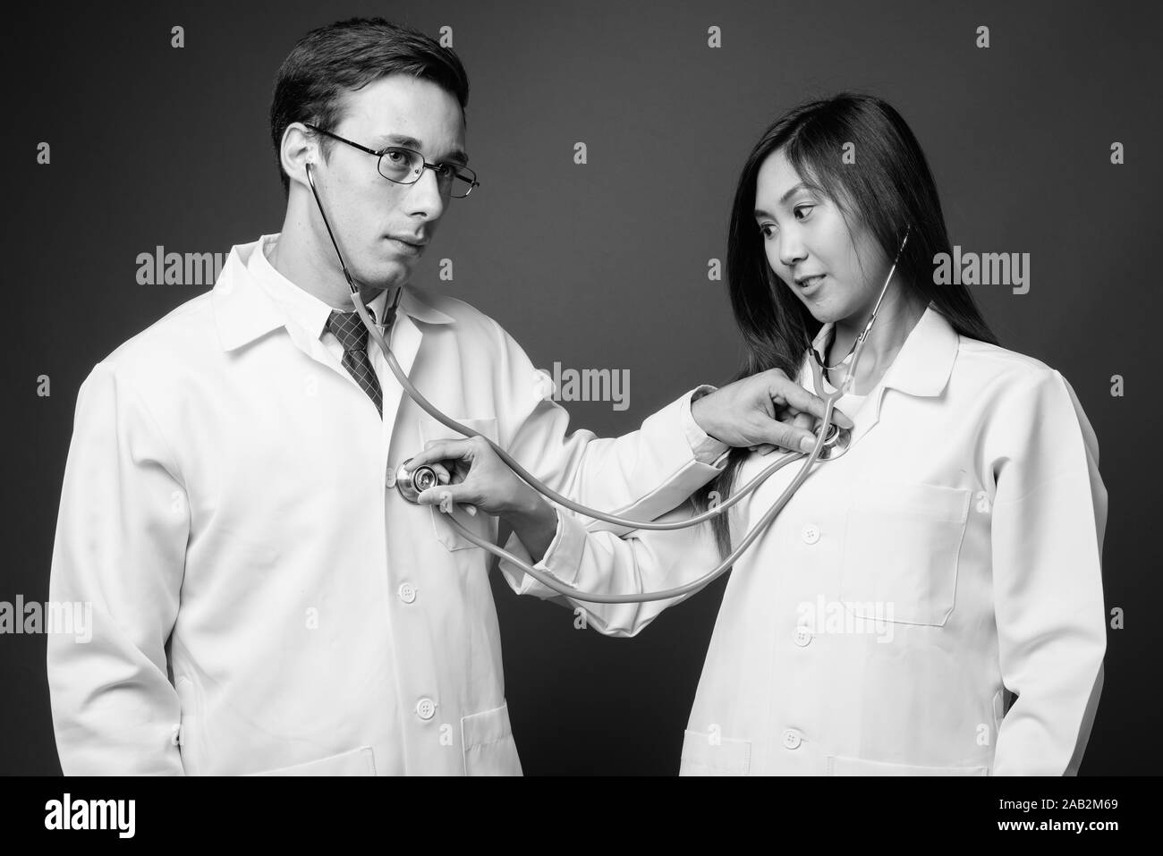 Portrait of two young multi ethnic doctors together in black and white ...