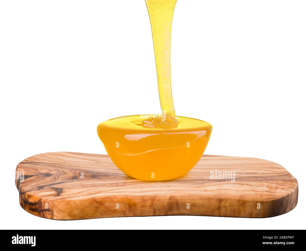Glass bowl full of honey and falling jet of honey on plank isolated on ...