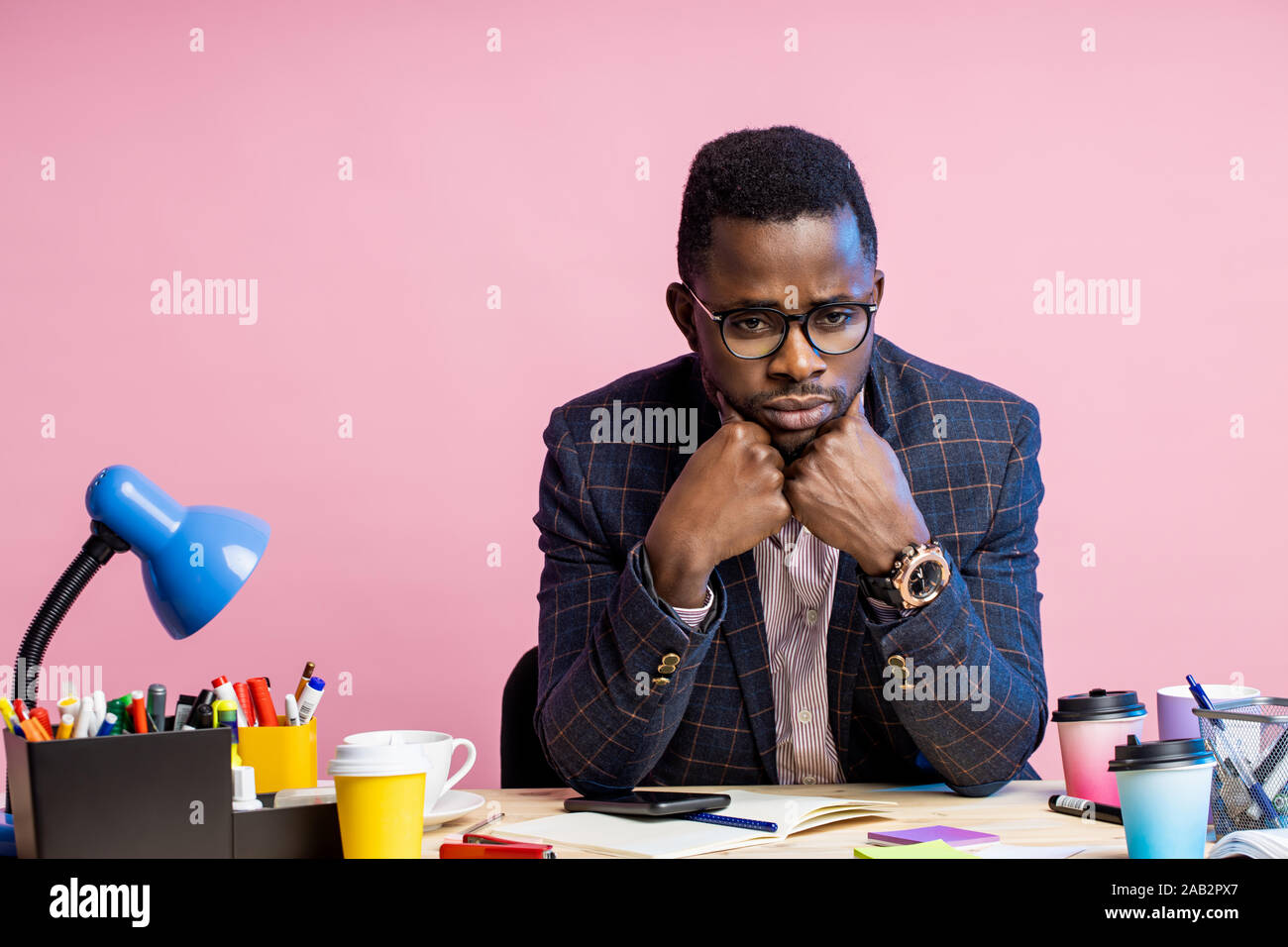 Portrait of tired unhappy young dark skinned manager sitting at ...