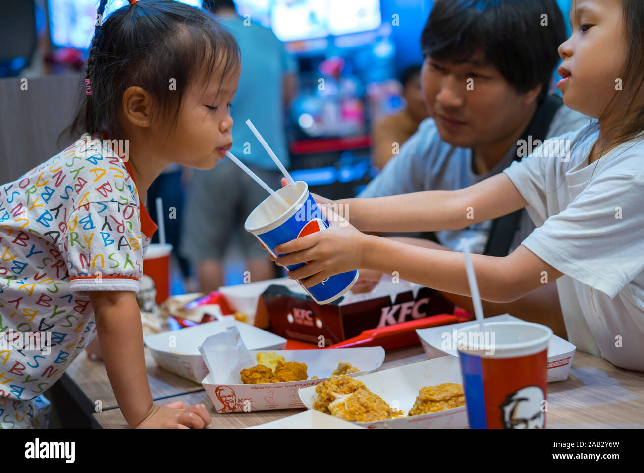 CHIANGMAI,THAILAND-Nov 14, 2019 : Little Child eating fried chicken with her family in the ...