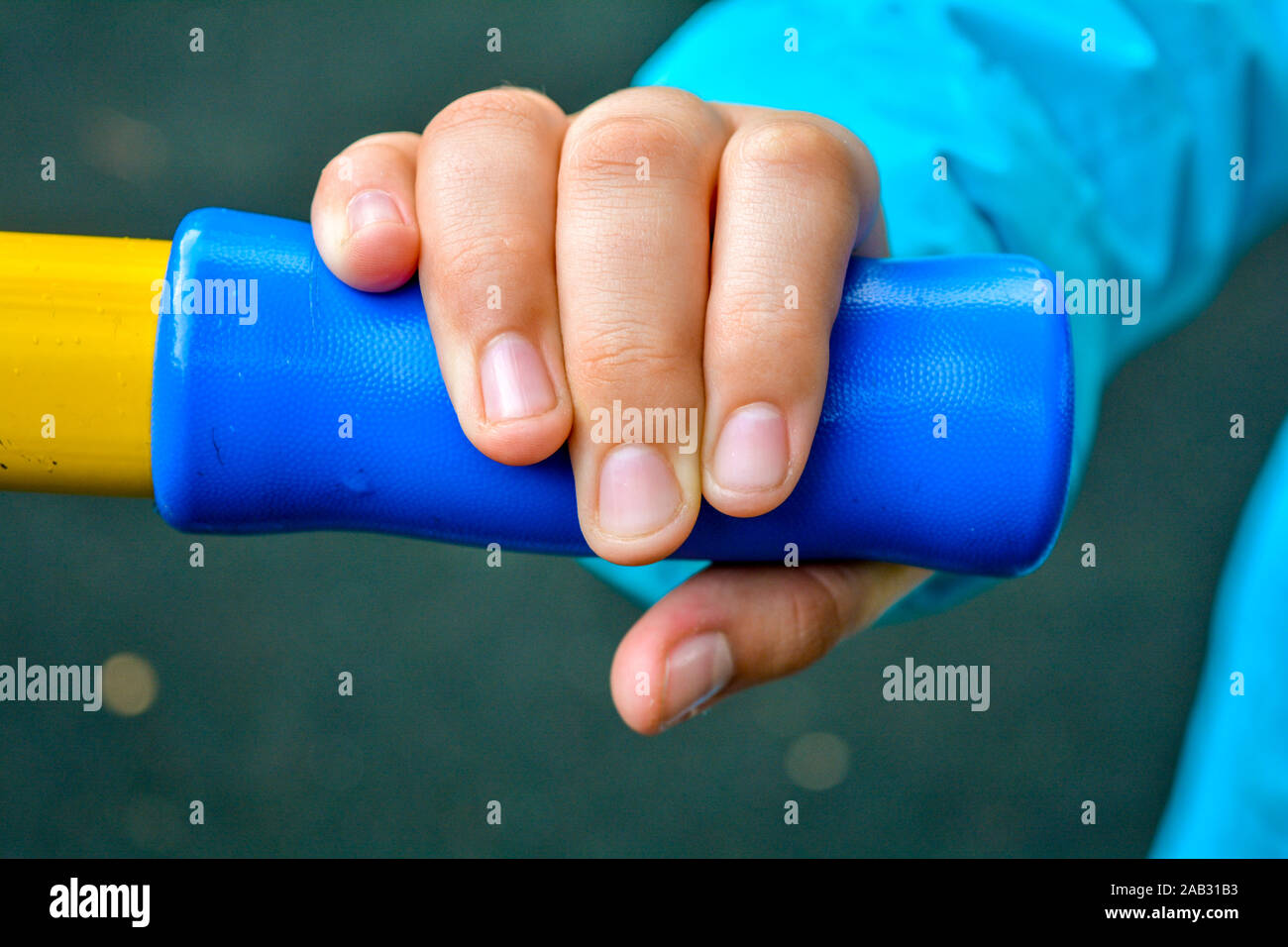 Close up of child hand holding handle of children's sports equipment on ...