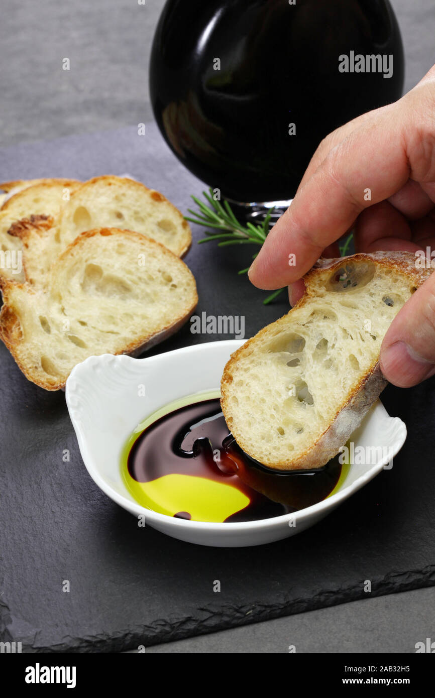 dipping baguette into balsamic vinegar and olive oil sauce Stock Photo ...